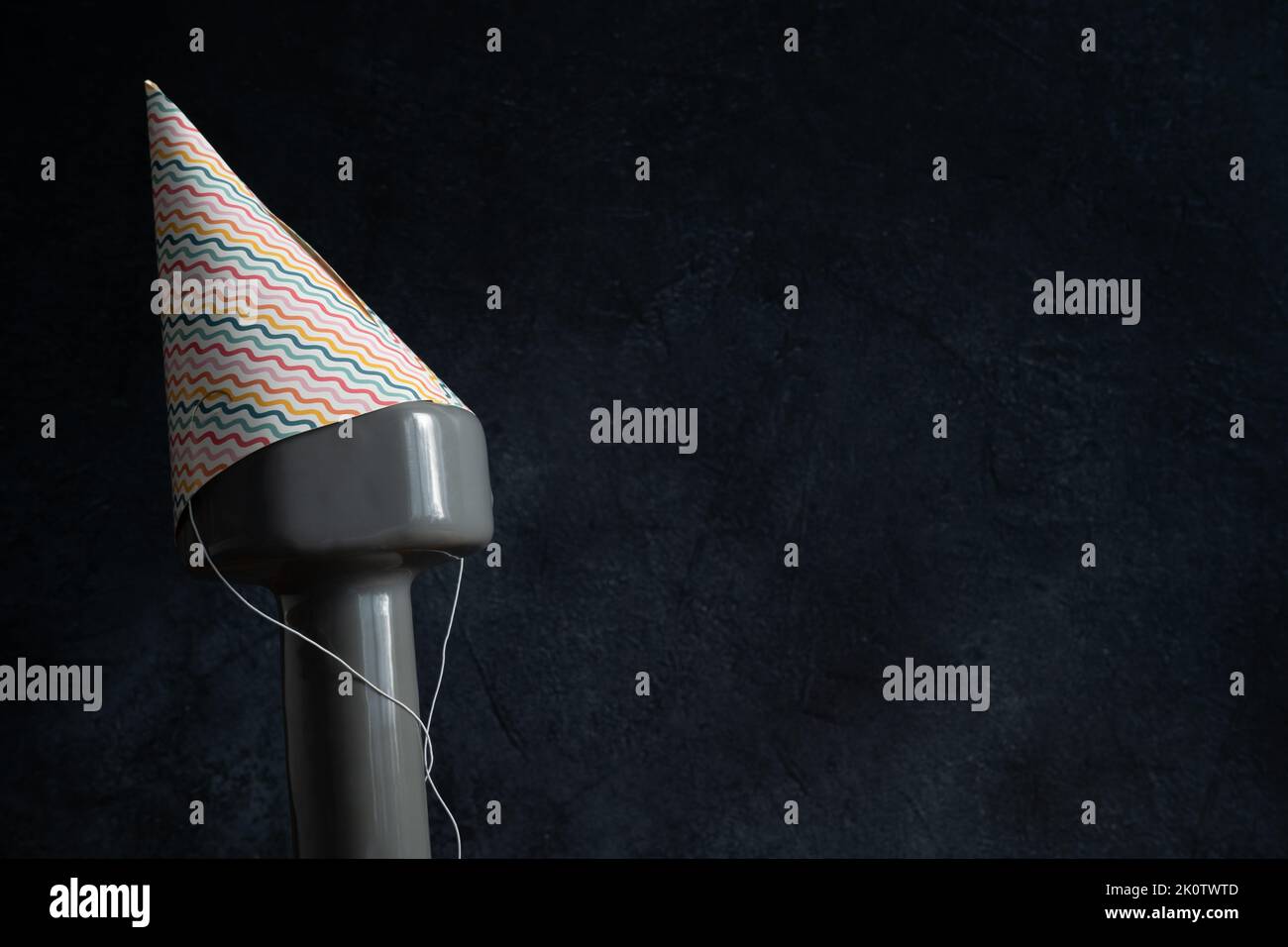 Heavy gym dumbbell in a colorful Birthday party hat. Exercise equipment ...
