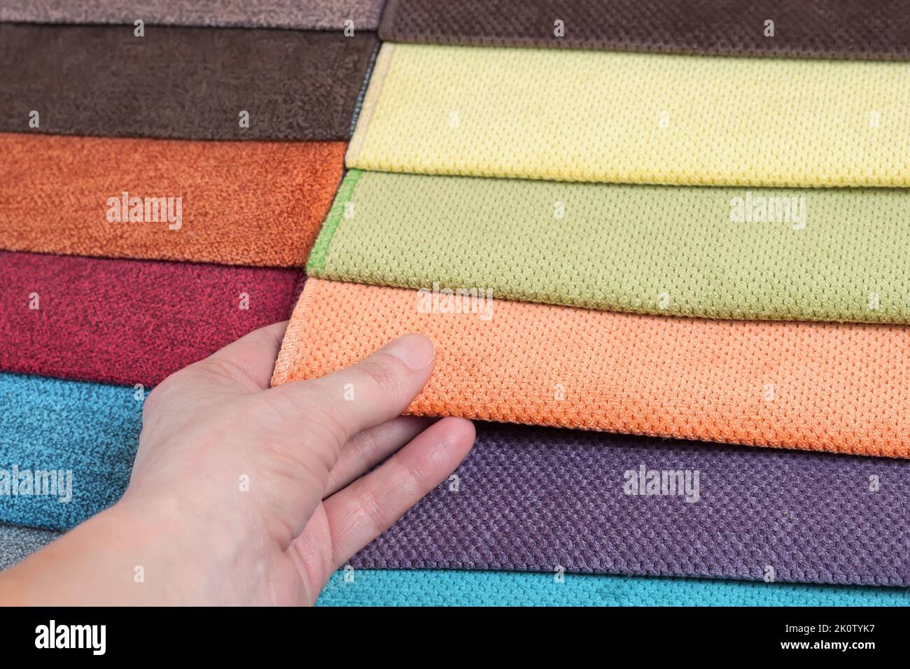 Woman chooses samples of colored fabric on table close up Stock Photo ...
