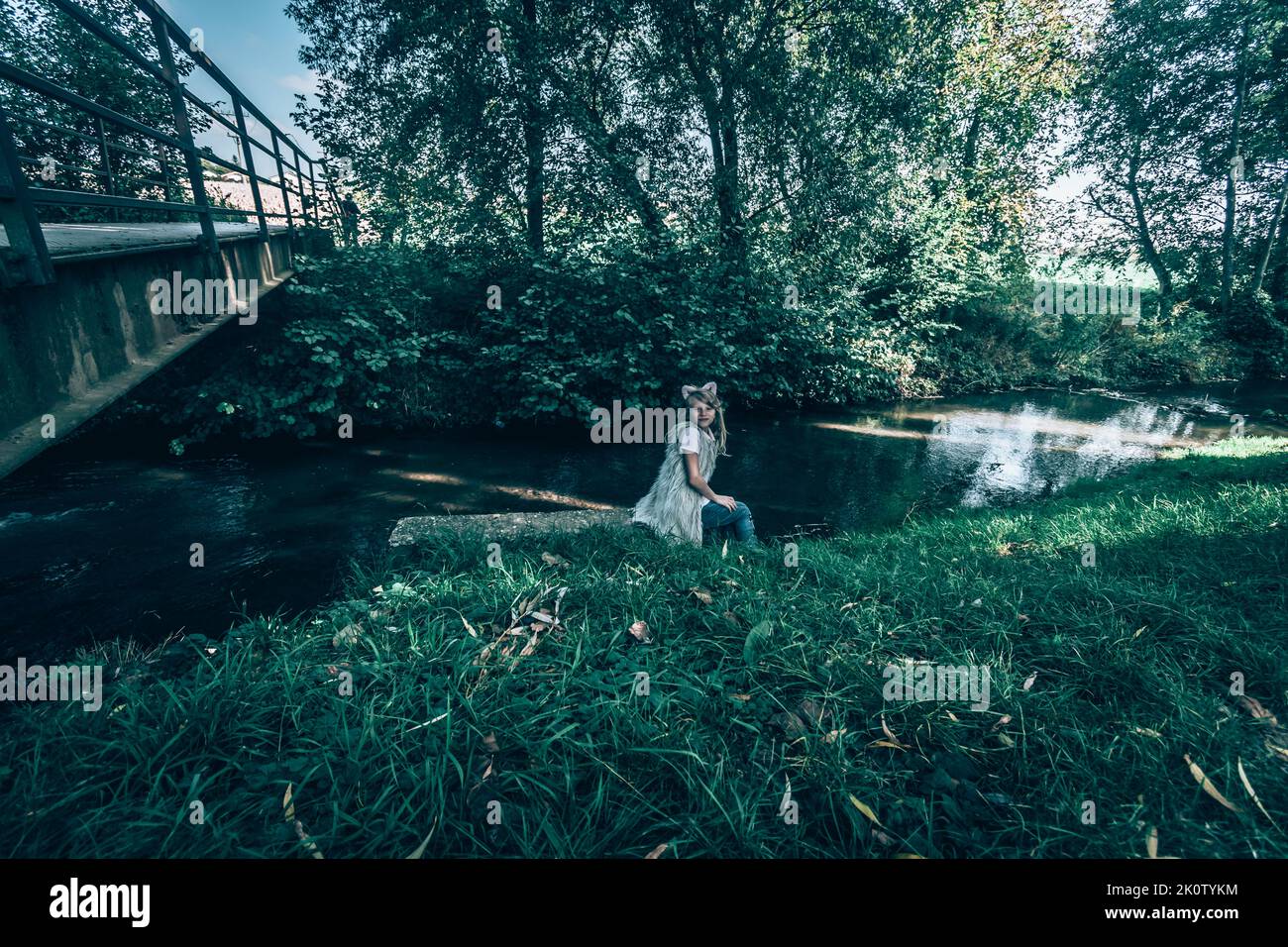 cute teenage girl sitting by the river in green spring nature Stock ...