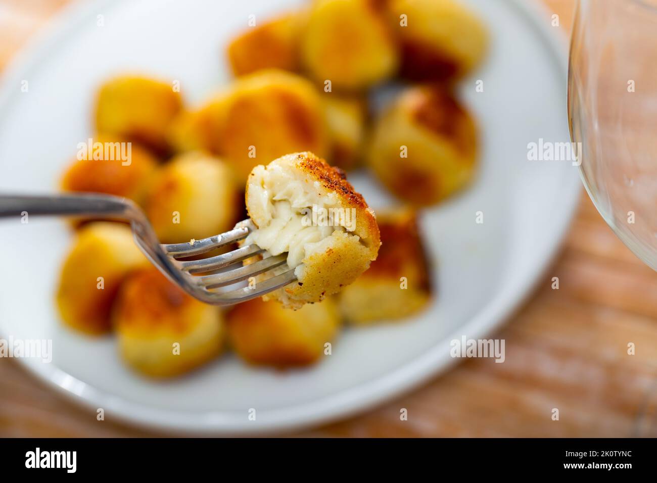 Fork with fried cheese croquette with crispy crust and soft filling ...