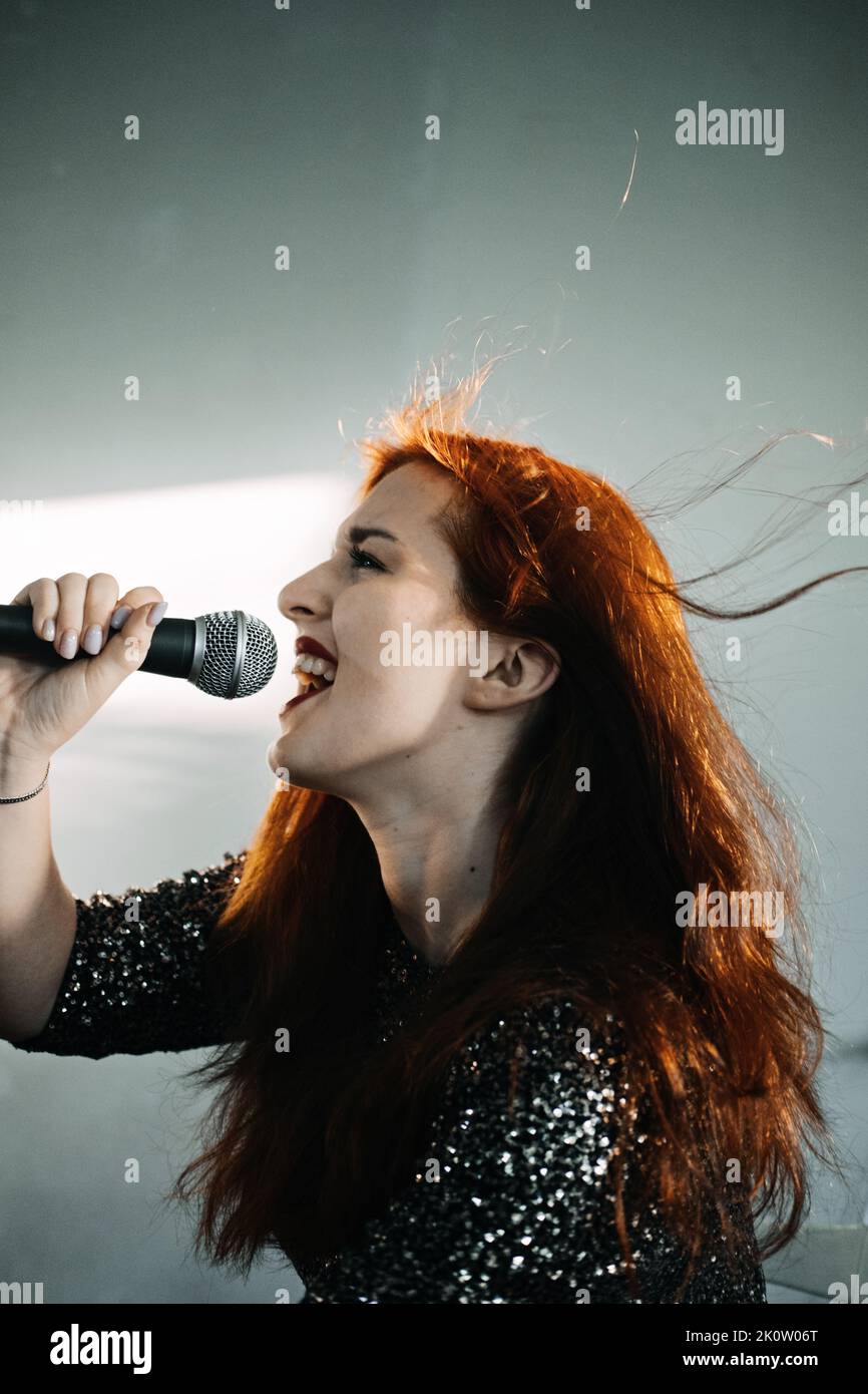 Portrait of redhead female singer woman in sparkly evening dress ...