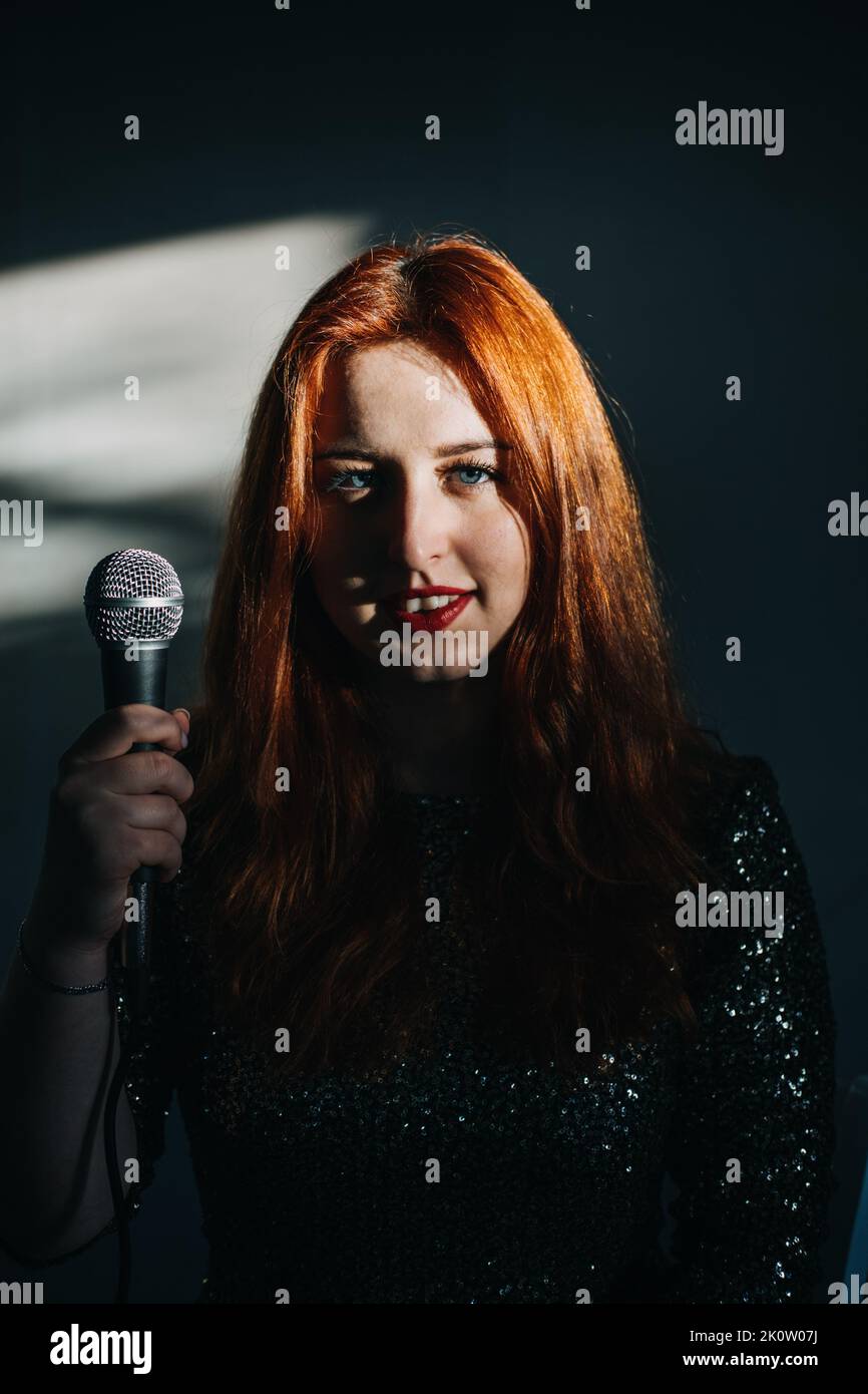Portrait of redhead female singer woman in sparkly evening dress ...