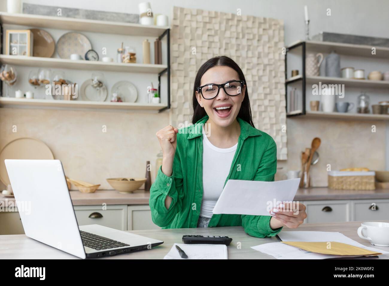 Happy young girl student in glasses and green shirt rejoices, received ...