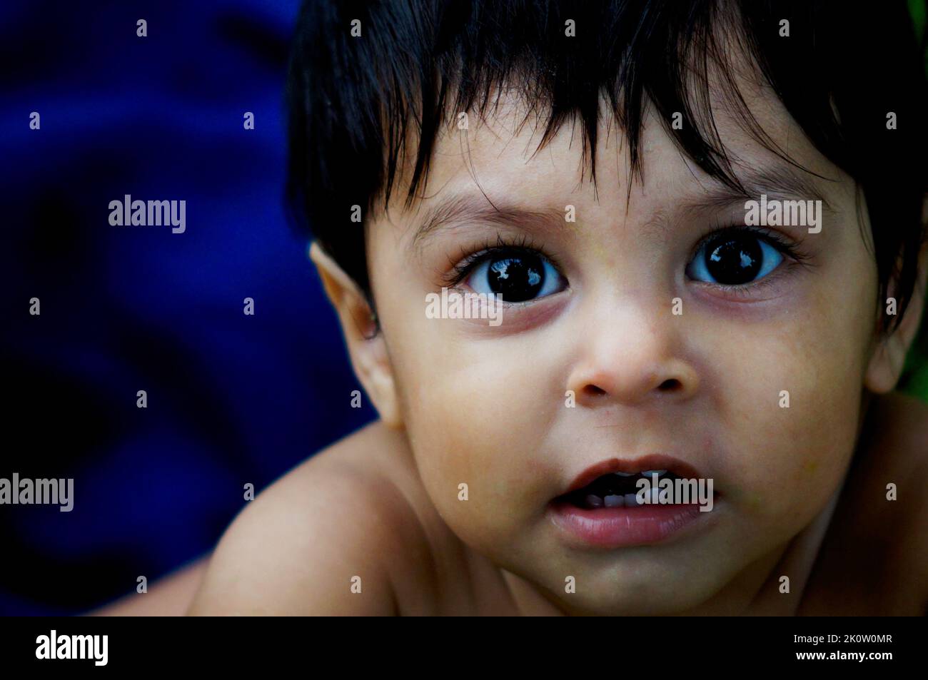 A Mexican baby staring at the camera with an expression of curiosity ...