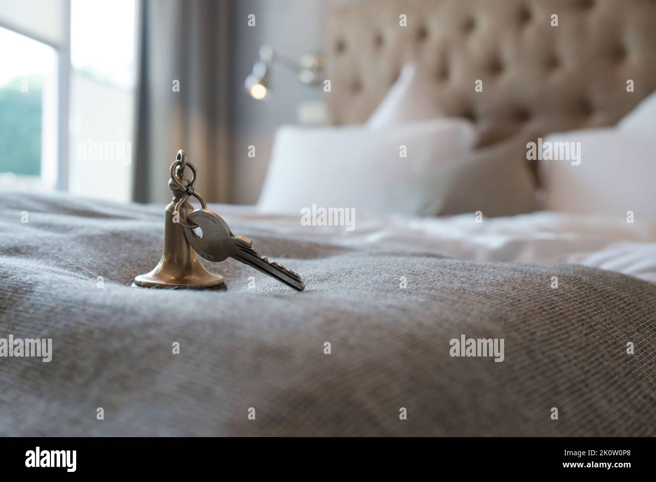 Key with a key fob from the hotel room lies on the bed Stock Photo - Alamy