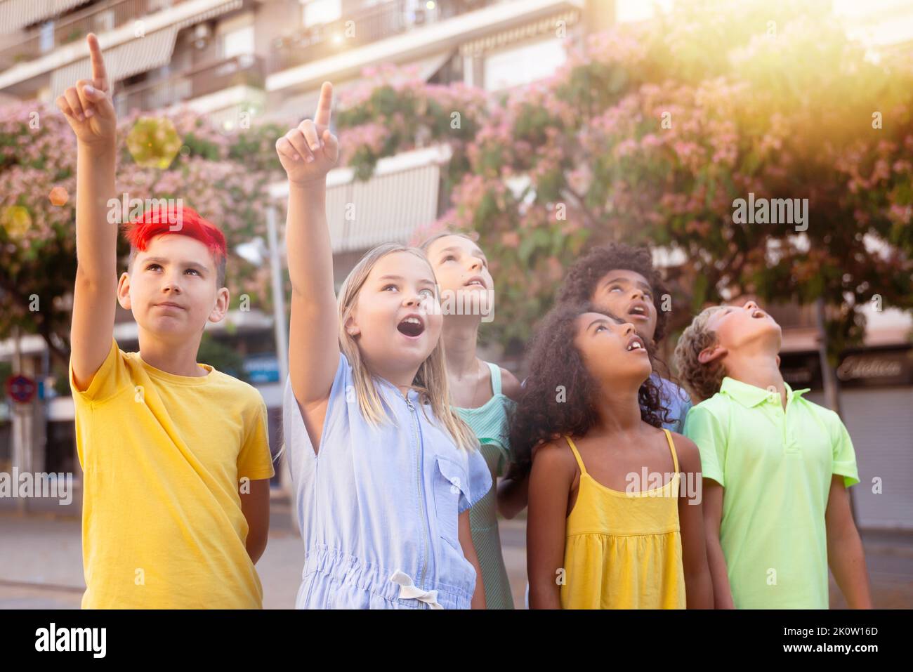 Group of surprised kids pointing fingers and looking up outdoors Stock ...
