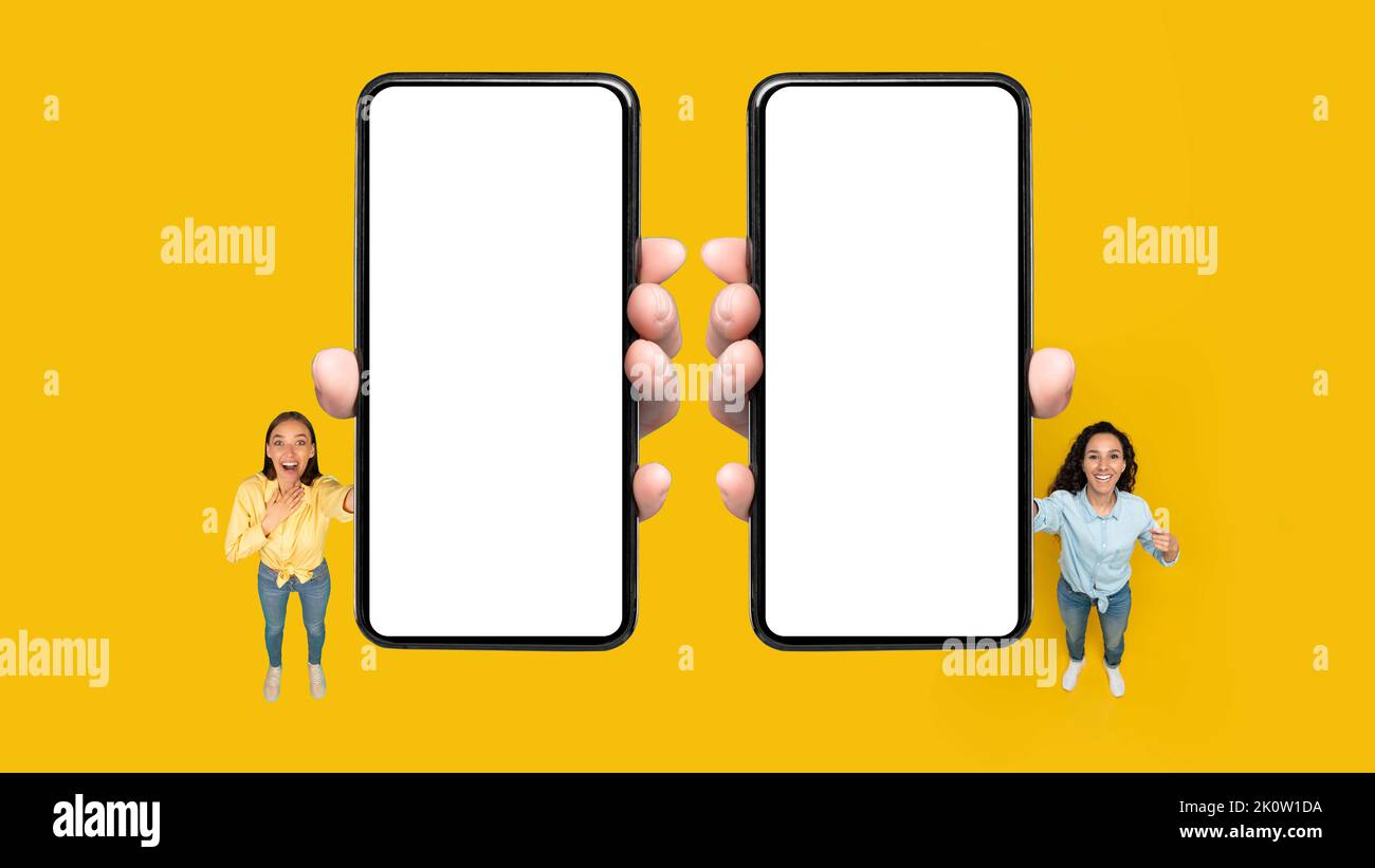 Two Ladies Showing Big Cellphones Empty Screens Over Yellow Background ...