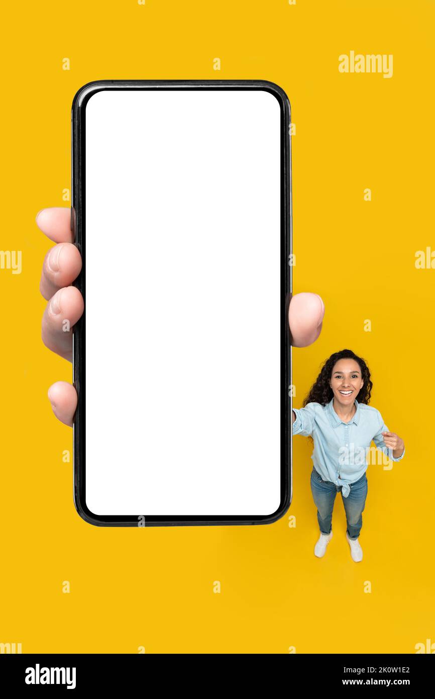 Lady Showing Large Phone With Empty Screen, Yellow Background, Vertical ...