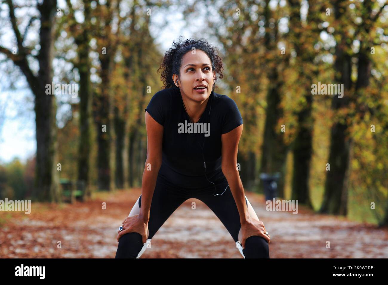 positive woman stretching outdoors preparing for exercise in sports ...