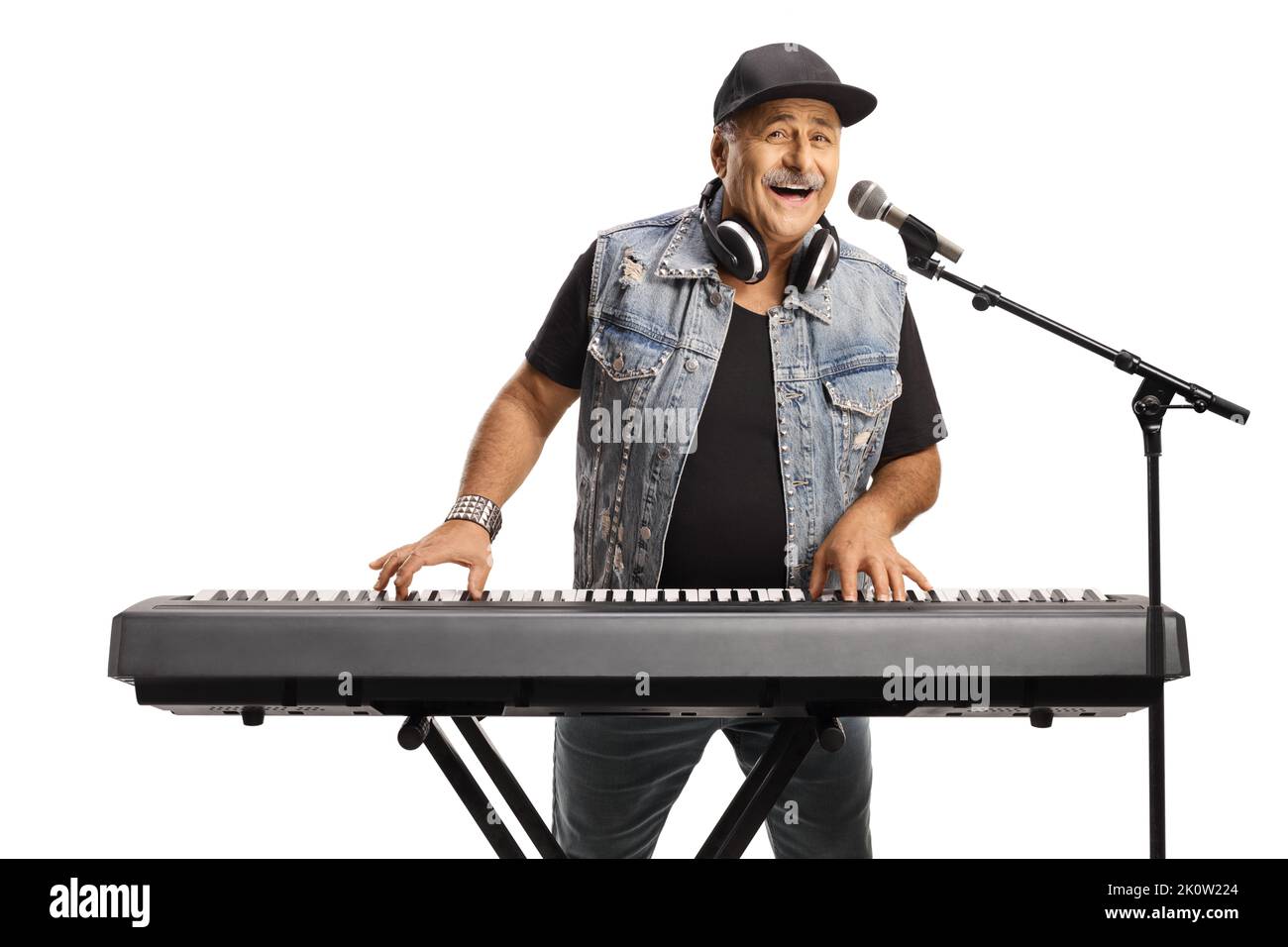 Mature man playing a keyboard and singing isolated on white background ...