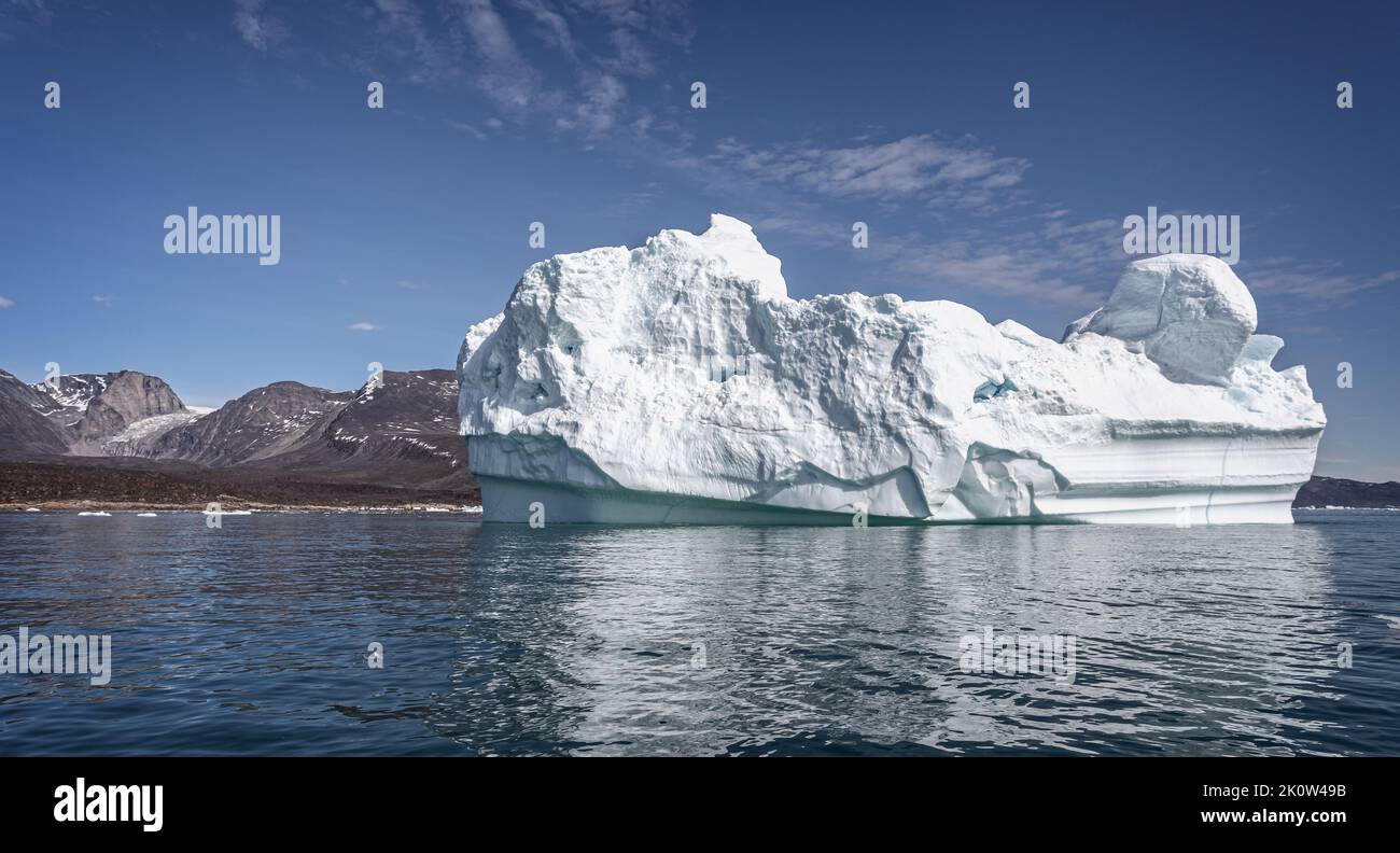 Massive iceberg with mountain backdrop in Disko Bay in Greenland Stock ...