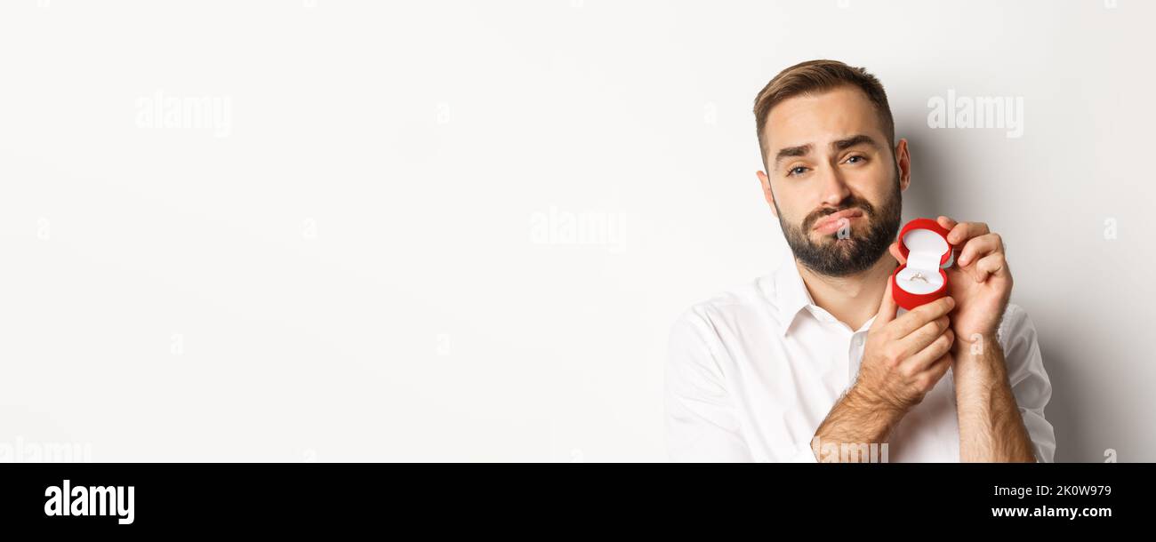 Close-up of hopeful man begging to marry him, looking sad and showing ...
