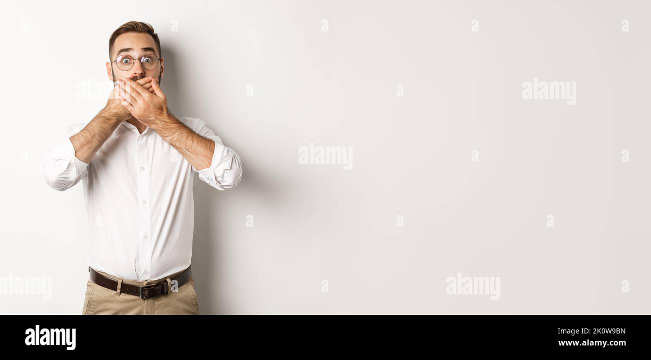 Shocked man gasping and looking at something in awe, covering mouth ...
