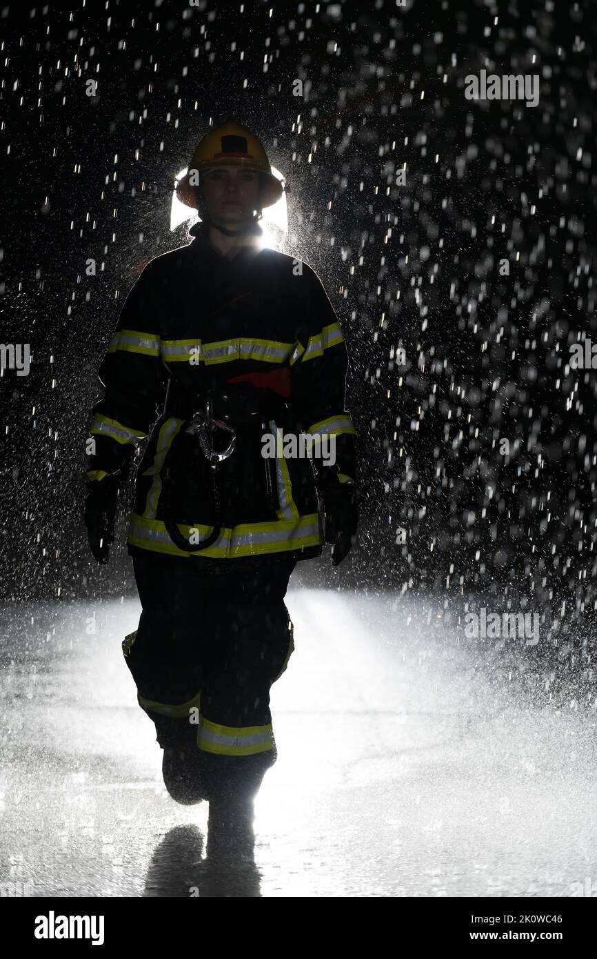 Portrait of a female firefighter standing and walking brave and ...