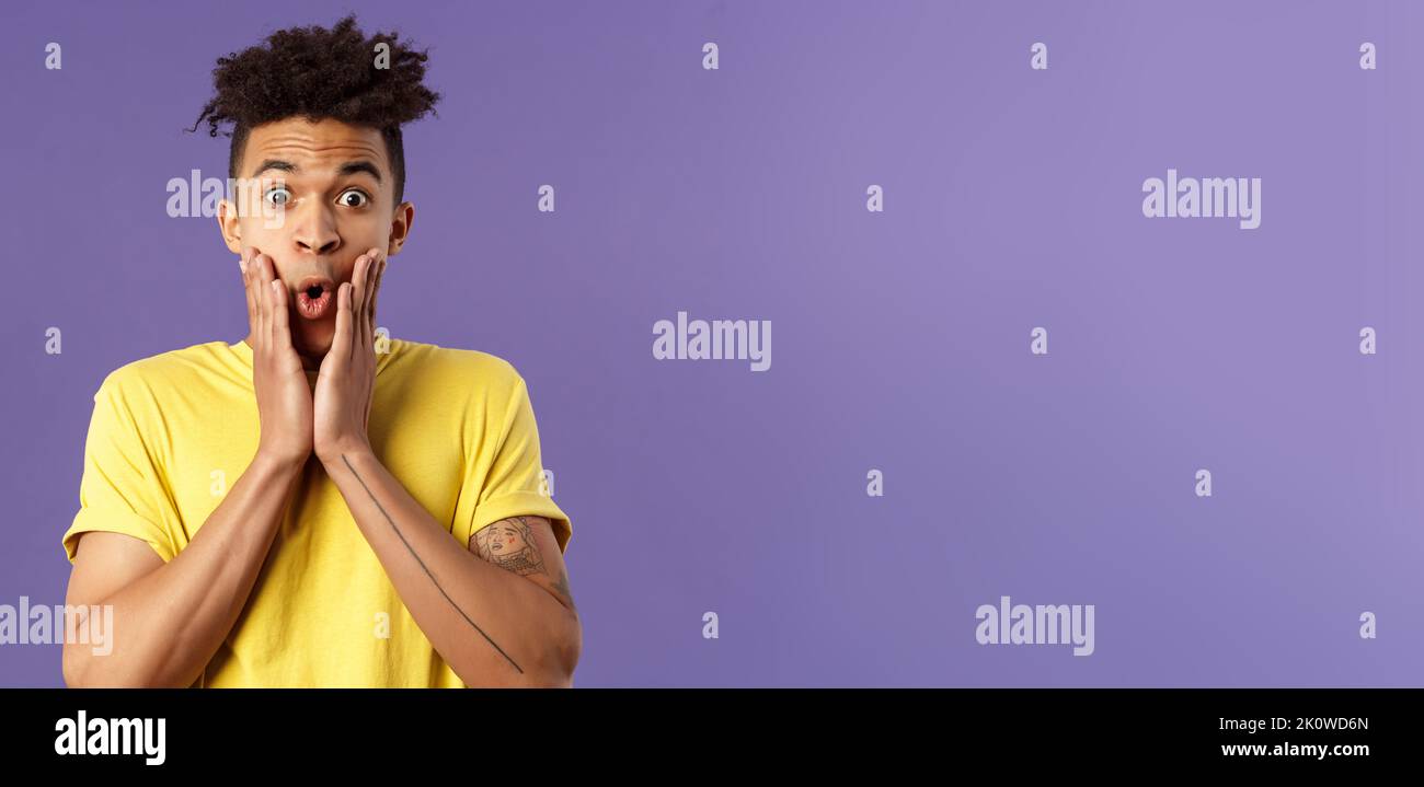 Portrait of astounded, intrigued young hispaic hipster guy listening to ...