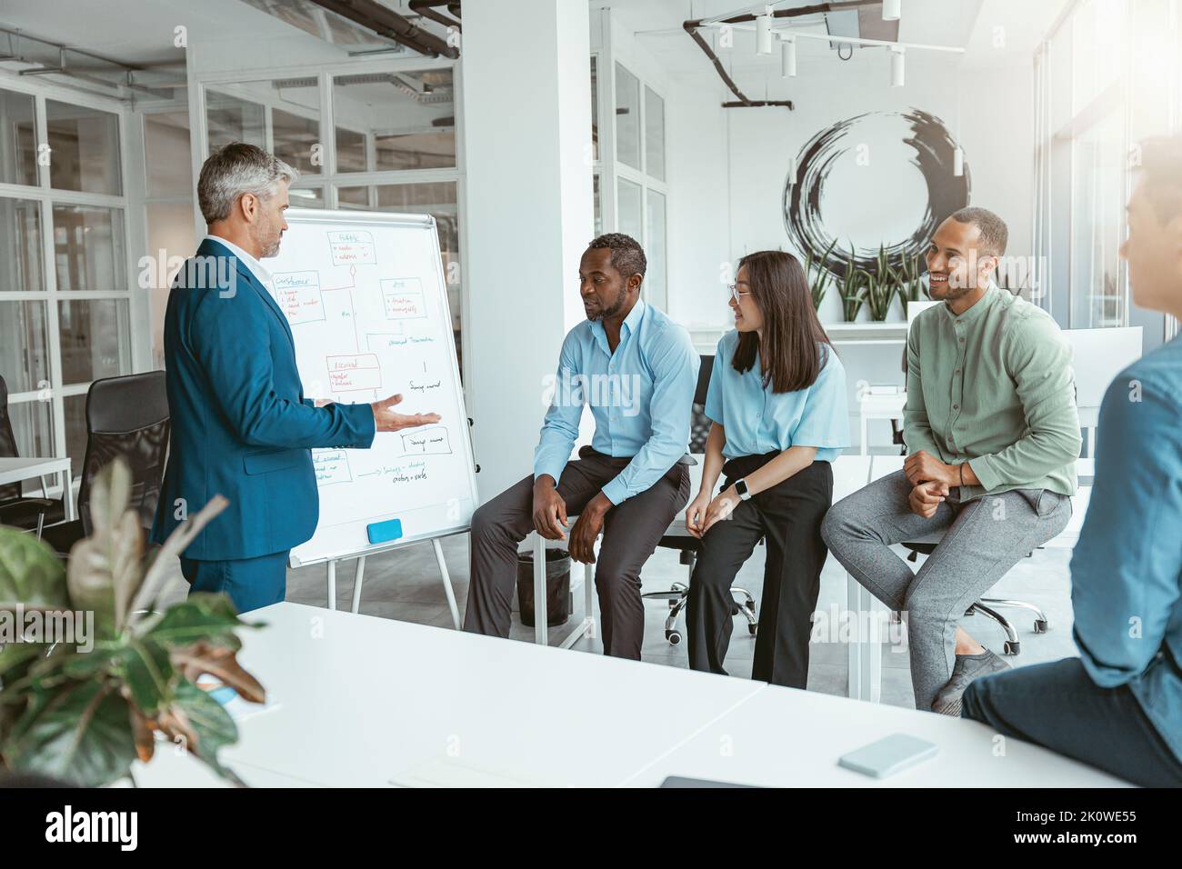 Male business coach or speaker make flip chart presentation to diverse ...