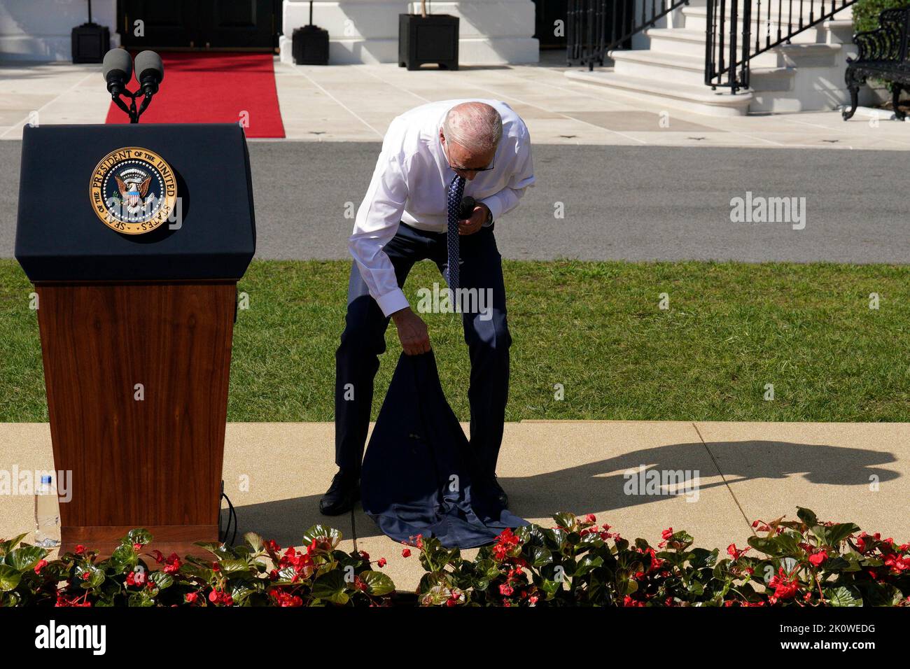 U.S. President Joe Biden reaches for his jacket at an event celebrating ...