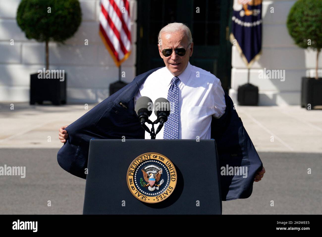 U.S. President Joe Biden takes out his jacket at an event celebrating ...