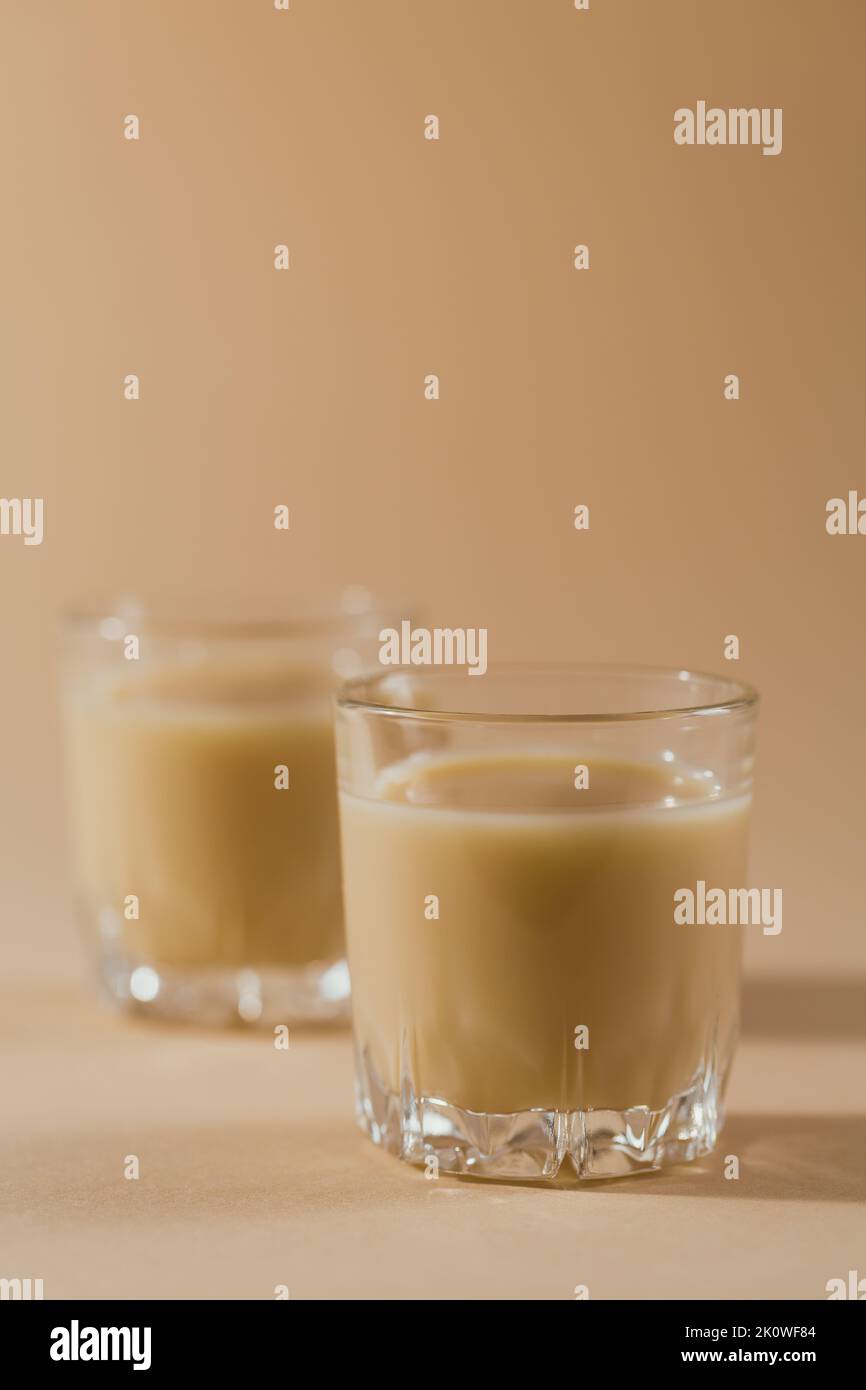 Short glasses of Irish cream Liquor or Coffee Liqueur on a light beige ...