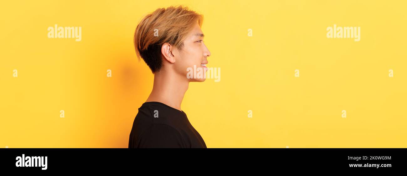 Profile of stylish handsome asian guy with fair hair looking left and ...