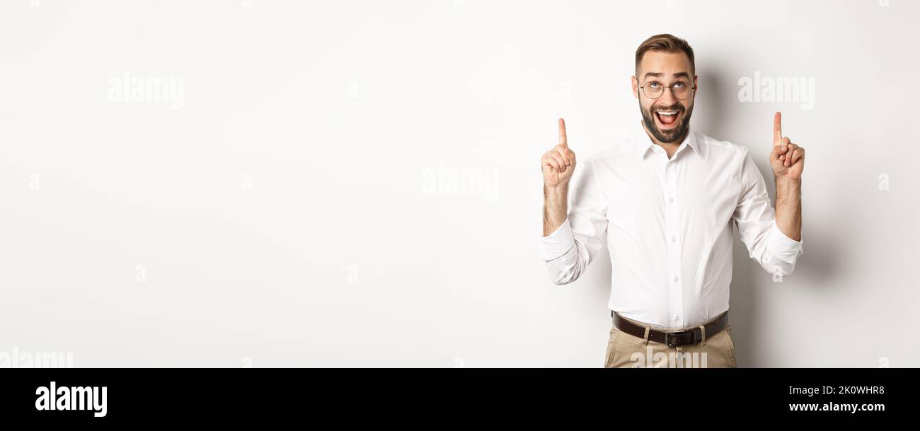 Excited businessman checking out advertisement, pointing and looking up ...