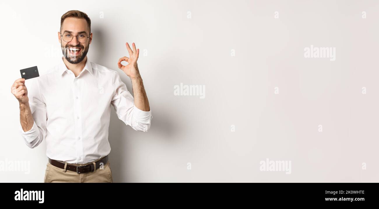 Handsome man showing his credit card and okay sign, recommending bank ...