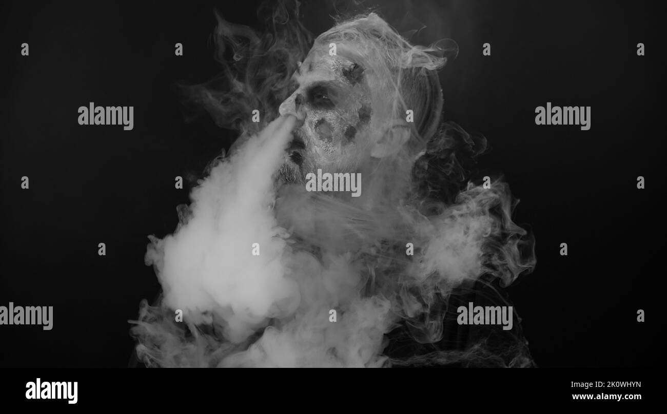 Frightening man with Halloween zombie bloody wounded make-up hiding ...