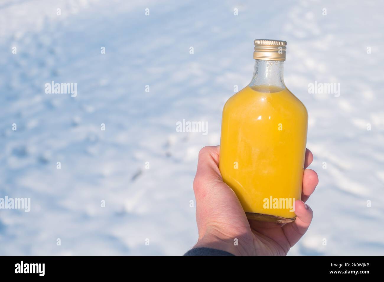 Hand holding small glass bottle with yellow drink - ginger shot, citrus ...