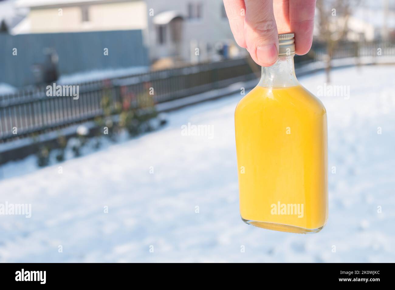 Hand holding small glass bottle with yellow drink - ginger shot, citrus ...