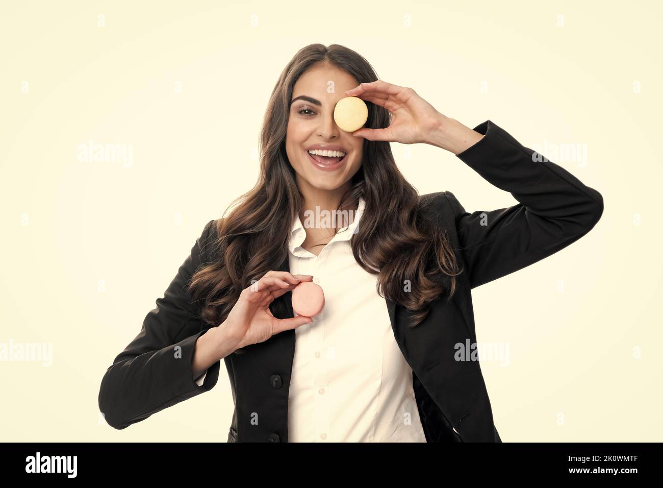 Young woman eating delicious macaroon on white background. Girl eat the ...
