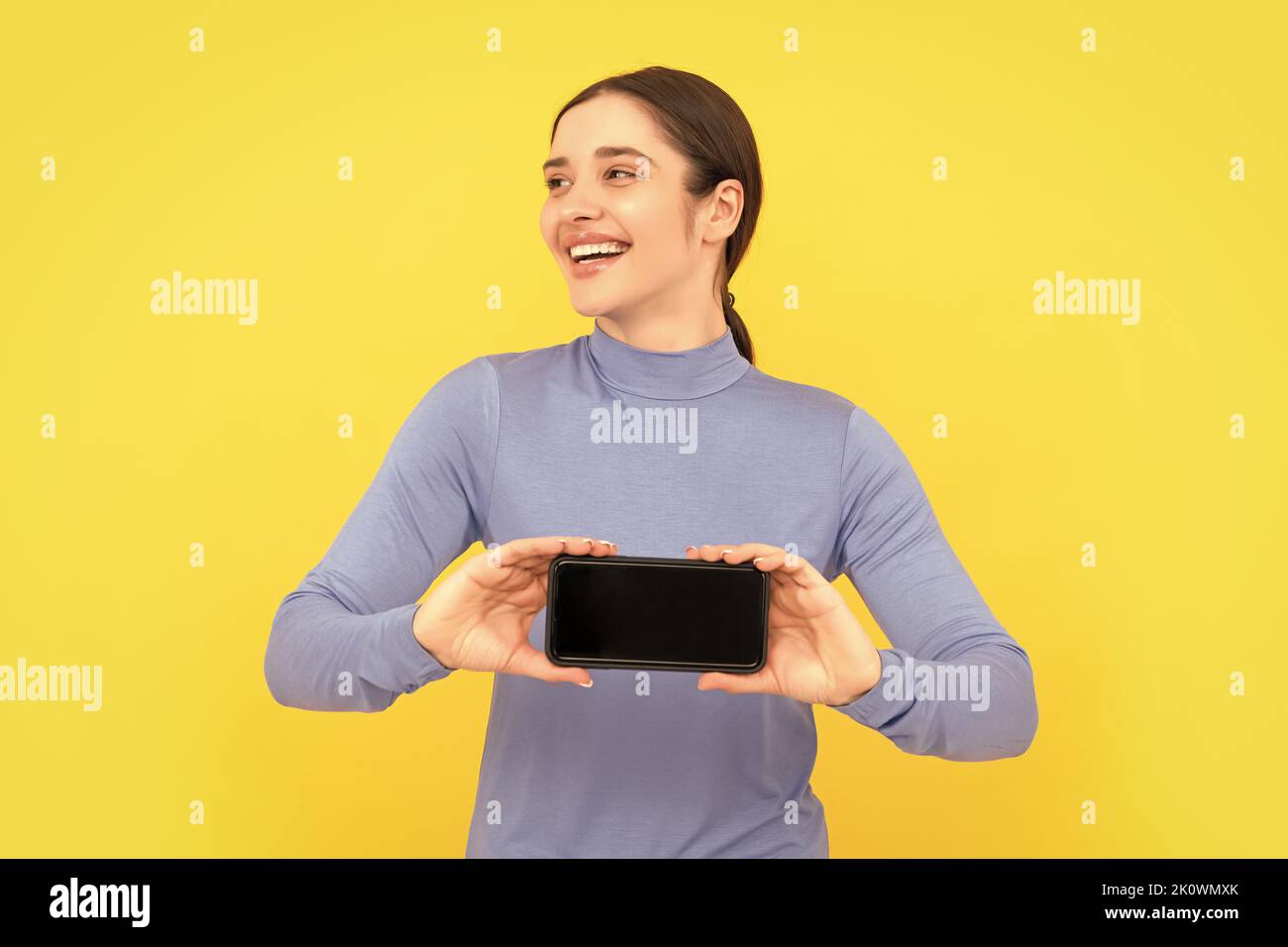 laughing lady showing smartphone screen with copy space, webinar Stock ...