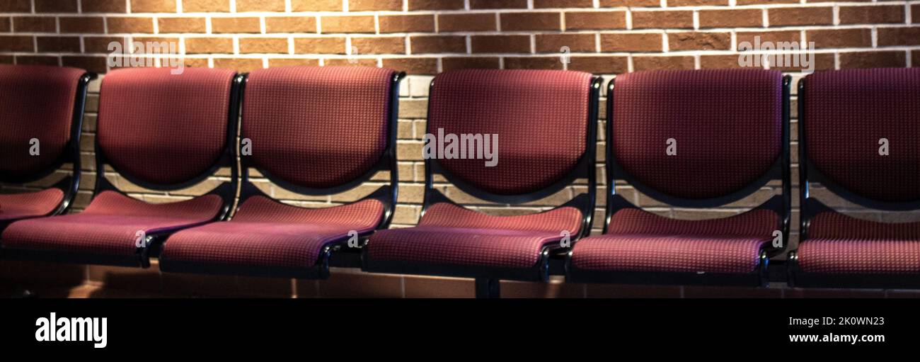 A row of theatre seats in front of a brick wall Stock Photo - Alamy