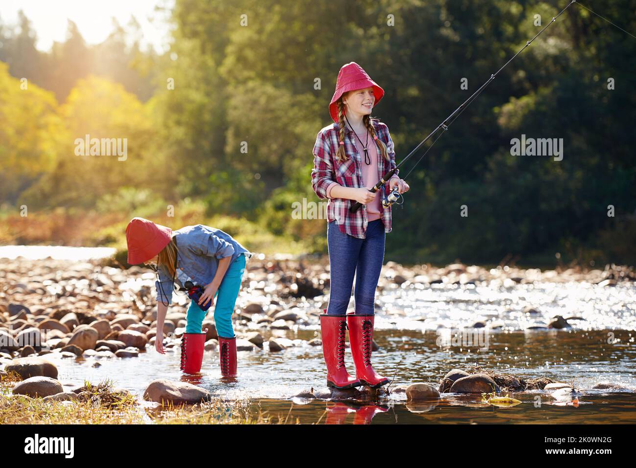 Theyre hooked on fishing. two young girls fishing by a river Stock ...
