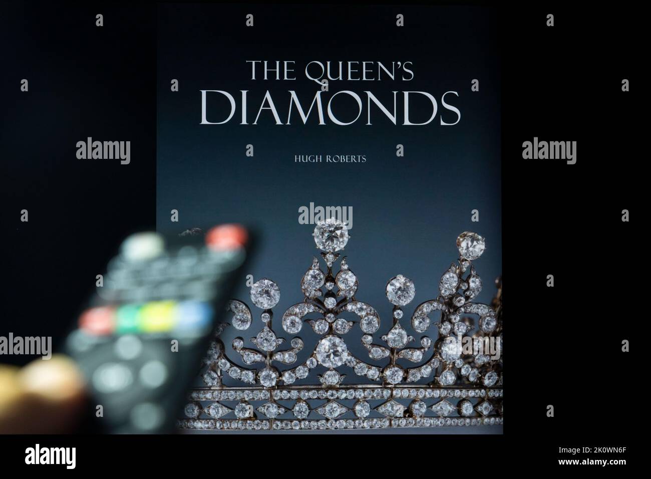 Belgrade, Serbia - September 12, 2022: The Queens Diamonds book cover on tv screen with remote ...