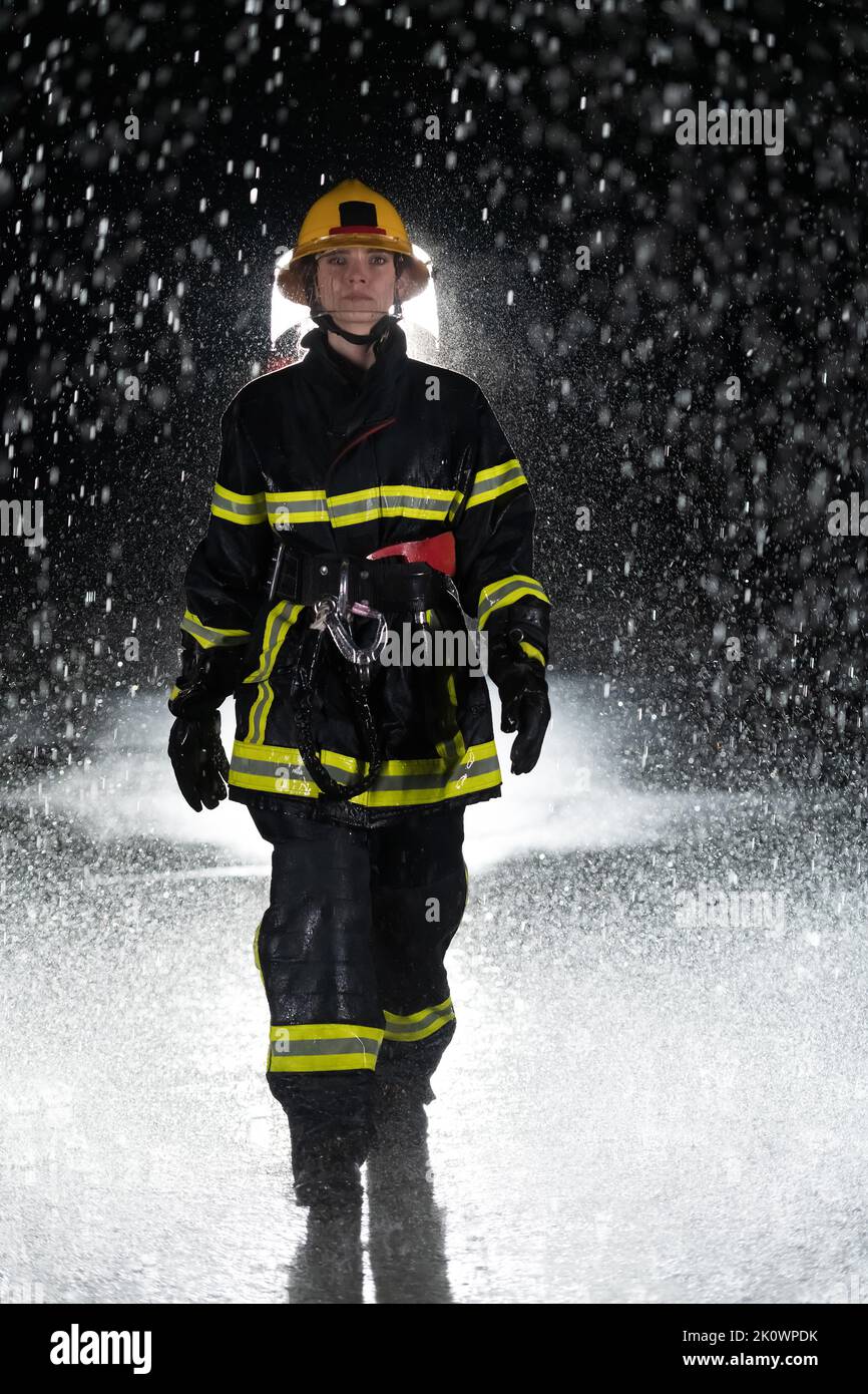 Portrait of a female firefighter standing and walking brave and ...