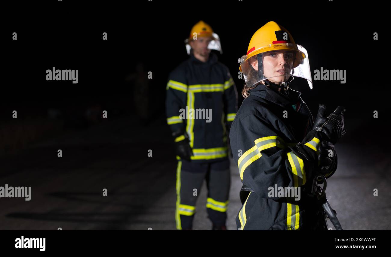 Firefighters using a water hose to eliminate a fire hazard. Team of ...