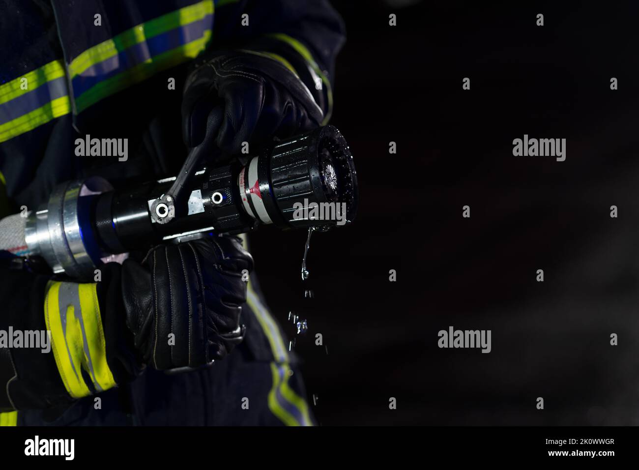 Firefighters use a water hose to eliminate a fire hazard. Team of ...