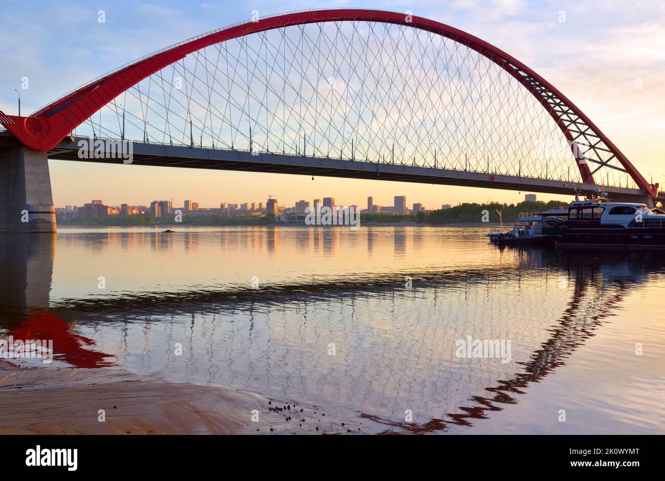 A large arched bridge at dawn. Bugrinsky Bridge over the Ob River on ...