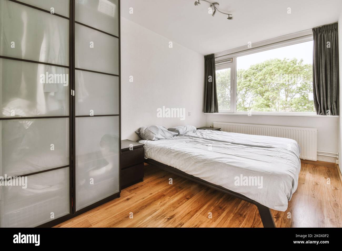 Home interior design of bedroom with bed and wooden wardrobe placed in ...