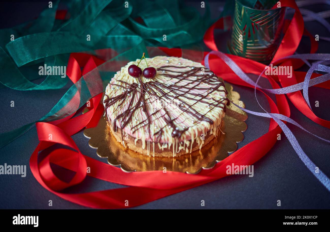 A tasty cherry cake with green and red ribbons around Stock Photo - Alamy