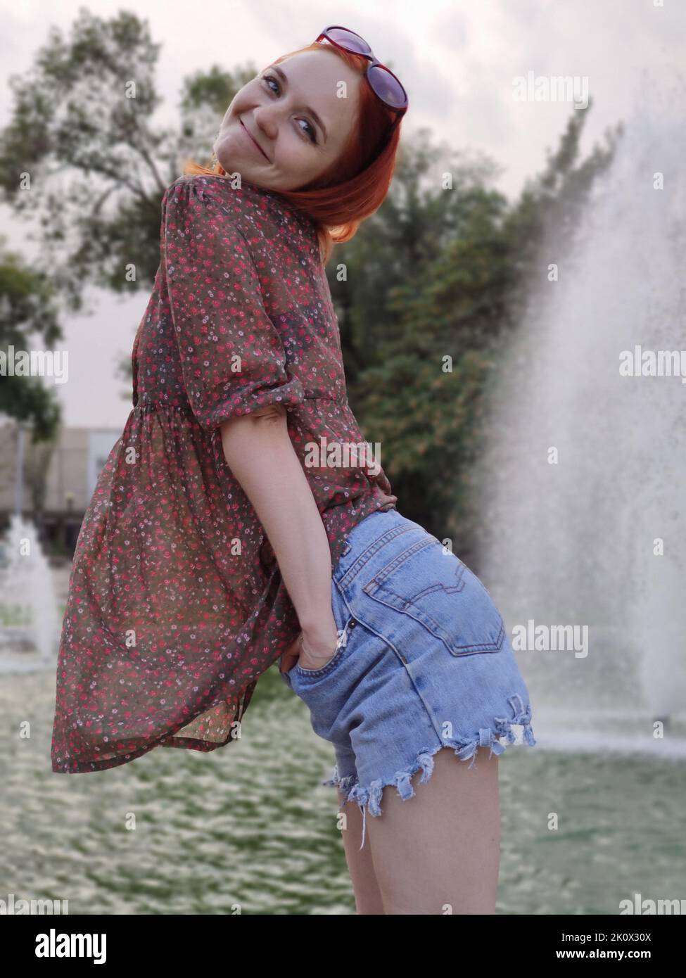 Pretty Young Redhead Woman In Denim Shorts And A Light Blouse
