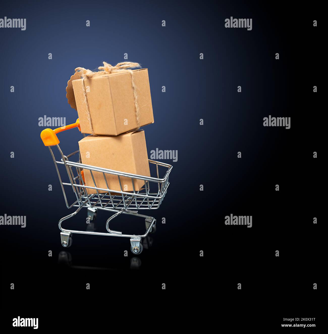 Cardboard boxes in shopping cart on black background Stock Photo - Alamy