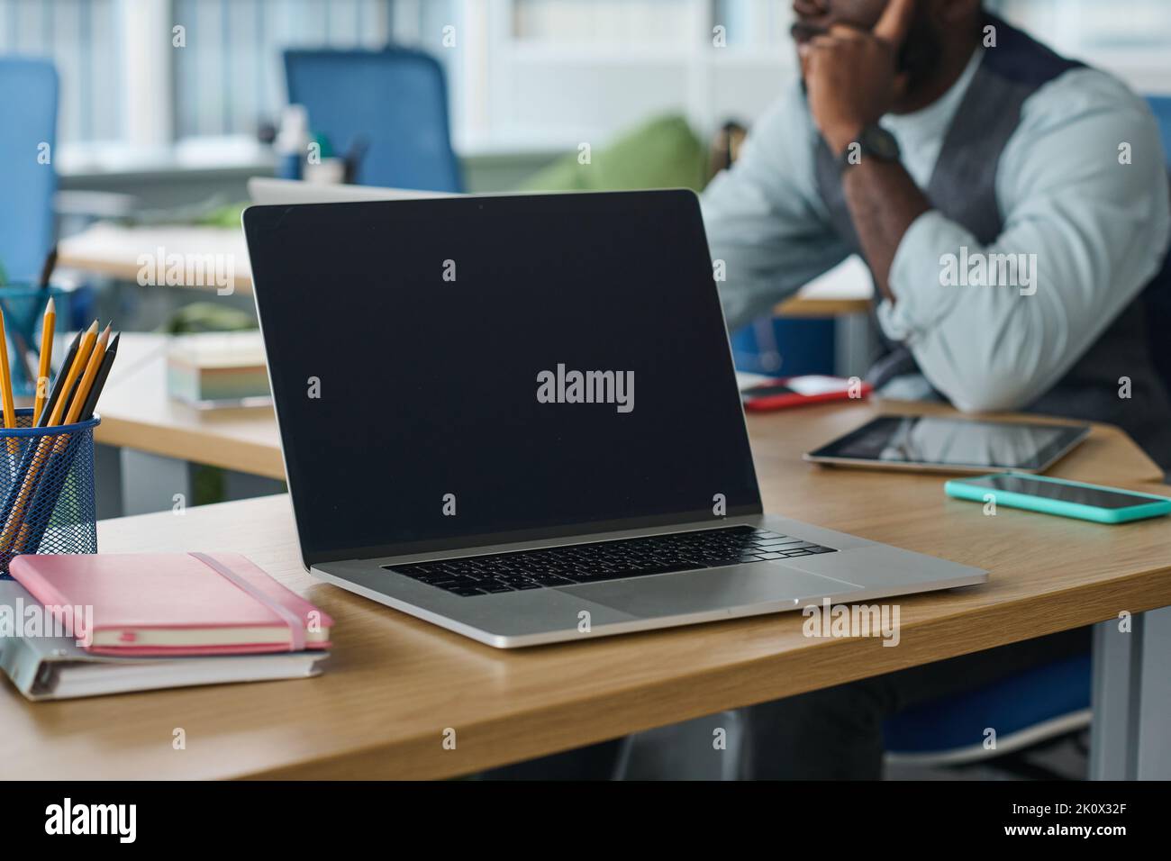 Laptop with black screen on workplace of modern office worker or ...