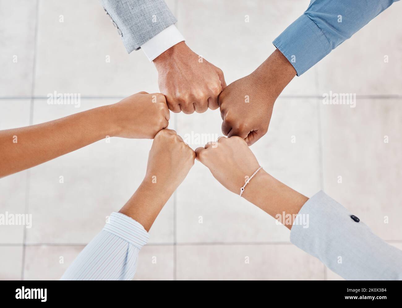 Diversity, team building and business people with their fist together to show teamwork ...