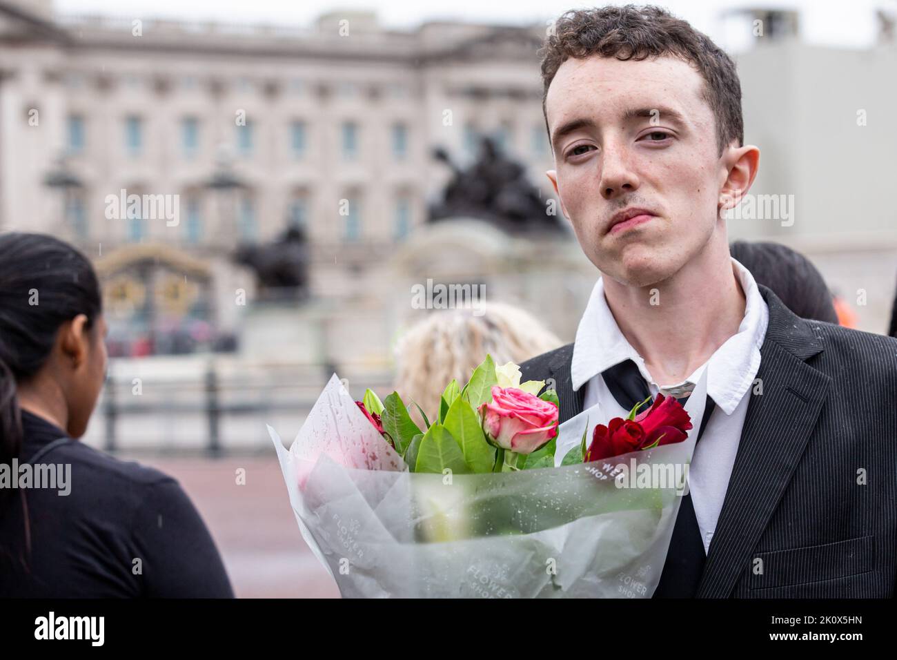 London, UK. 13th Sep, 2022. A young man with flowers arrives to pay ...