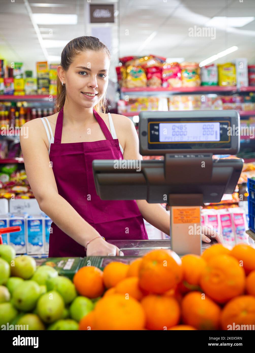 Portrait of a smiling seller girl standing behind the counter with ...