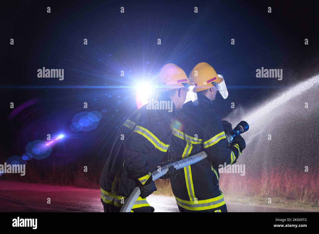 Firefighters use a water hose to eliminate a fire hazard. Team of ...