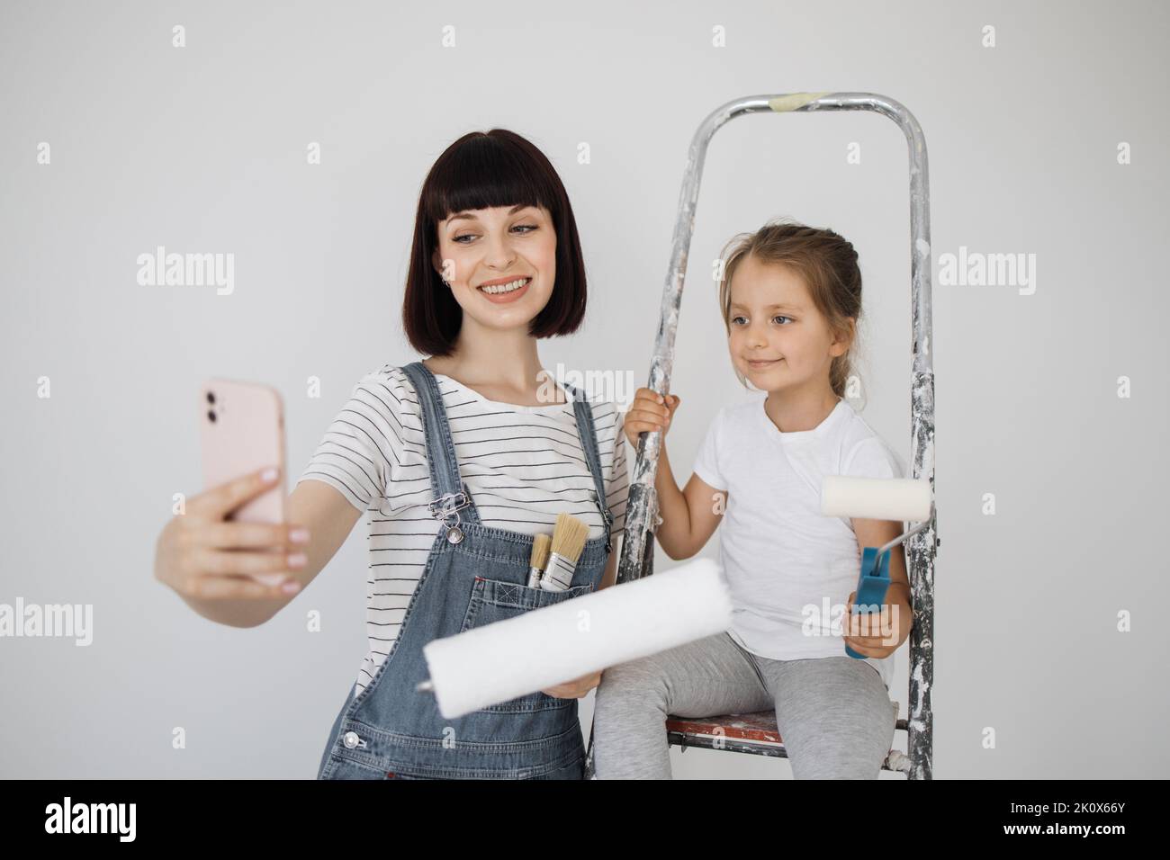 A cheerful happy family is renovating a purchased apartment, mom ...