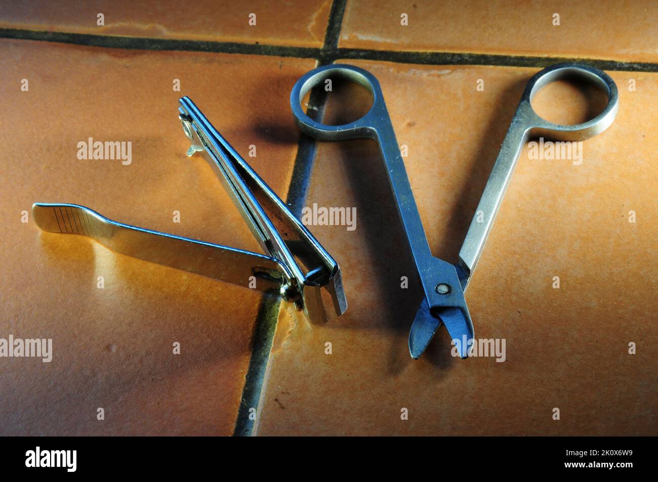 Finger nail scissors and clippers on quarry tile surface Stock Photo ...