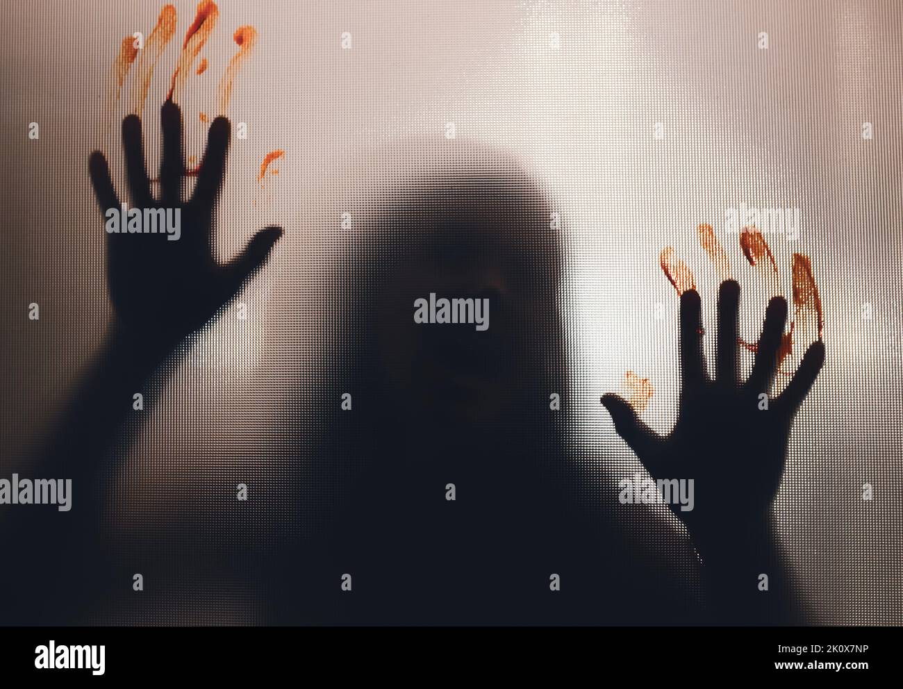 Horror ghost woman with blooded hands behind the matte glass. Halloween ...
